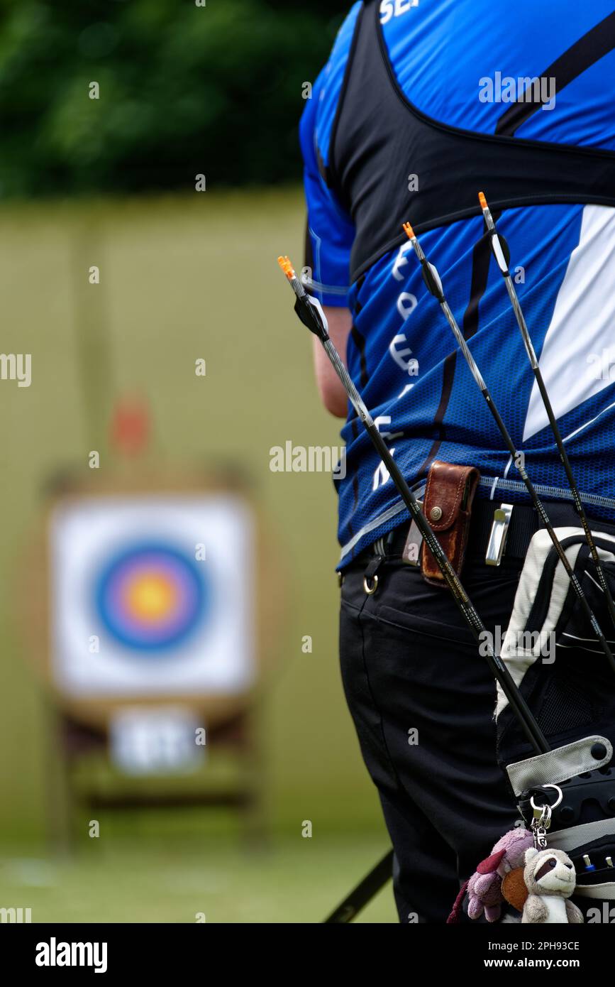 A back side view of an Archer standing in front of archery targets ...