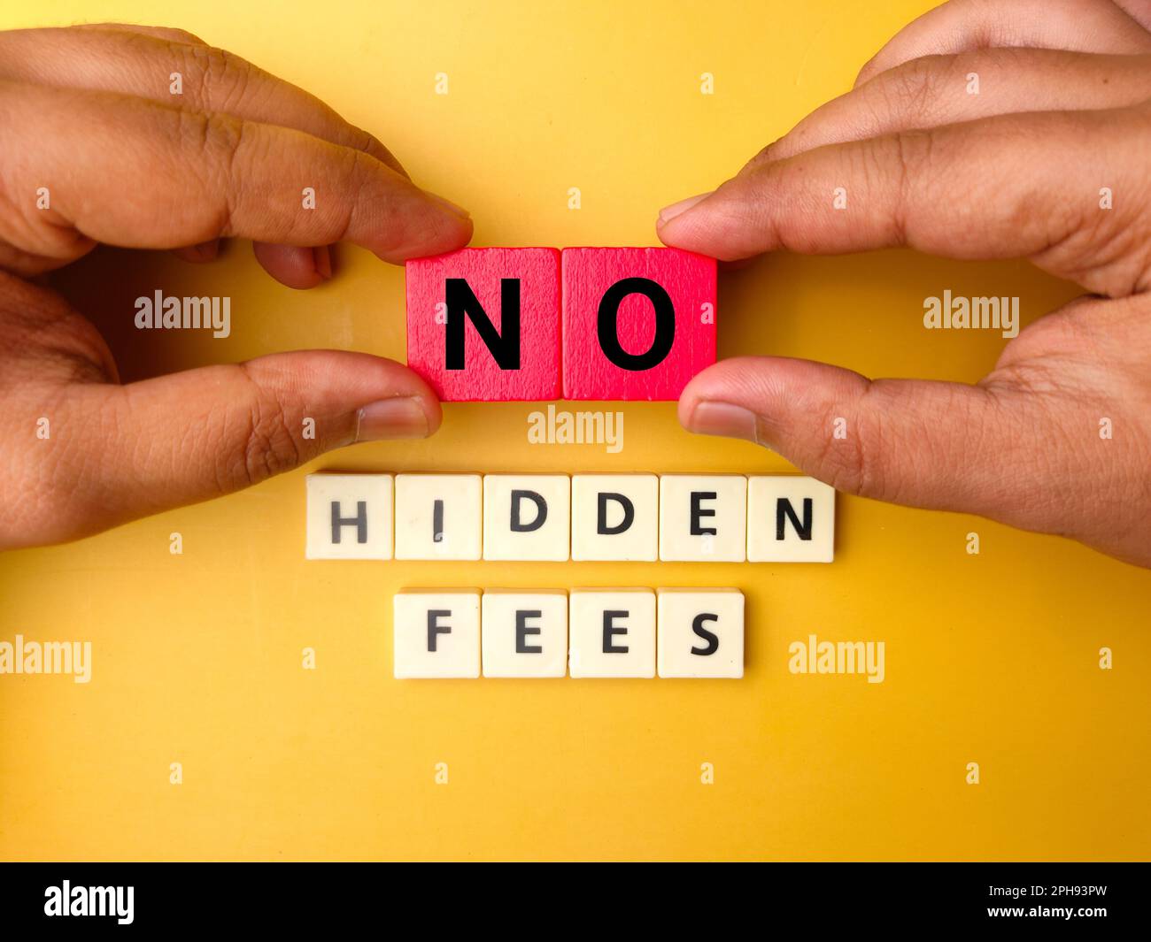 Hand holding colored cube with the word NO HIDDEN FEES on yellow ...