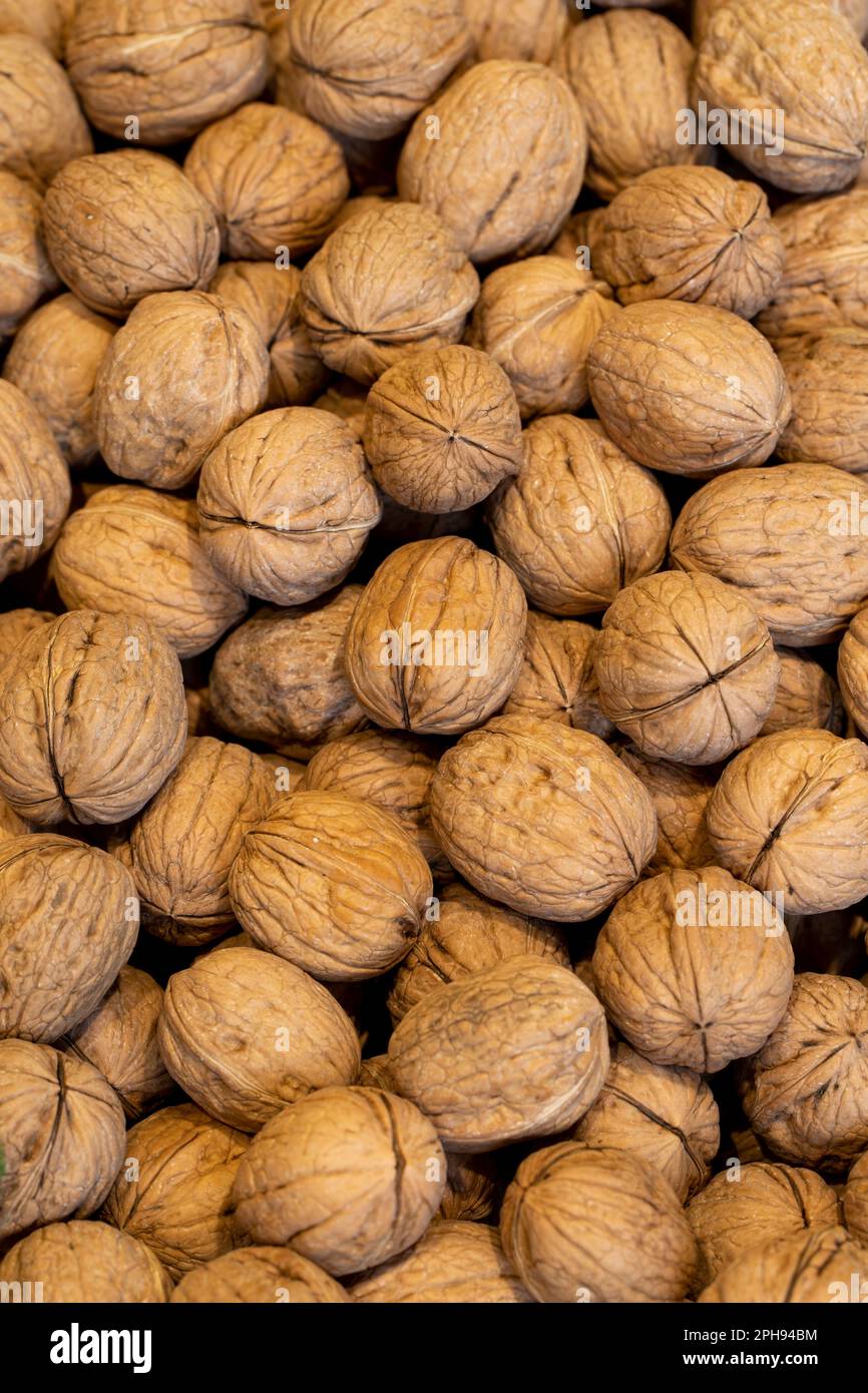 Shelled walnuts. Pile of unshelled walnuts in daylight. Walnut ...