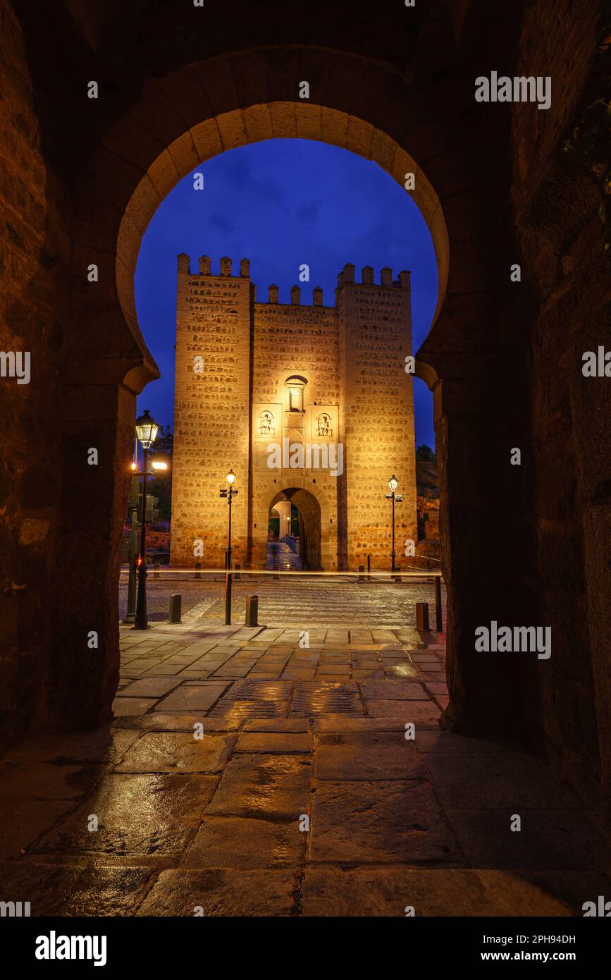 Toledo city, Spain. View at blue hour of a Moorish arch to Alcantara ...