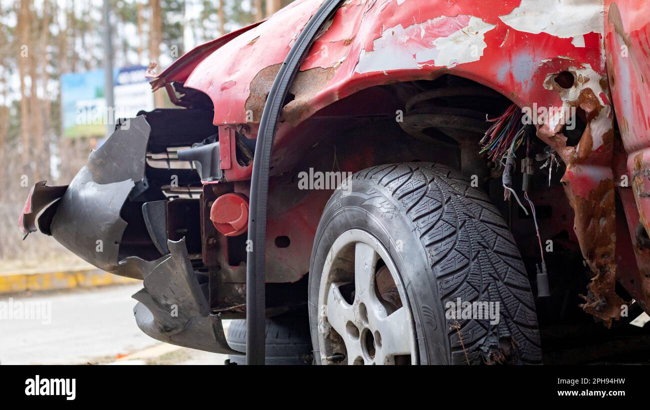 Broken rumpled red car after a severe accident with a skewed body ...