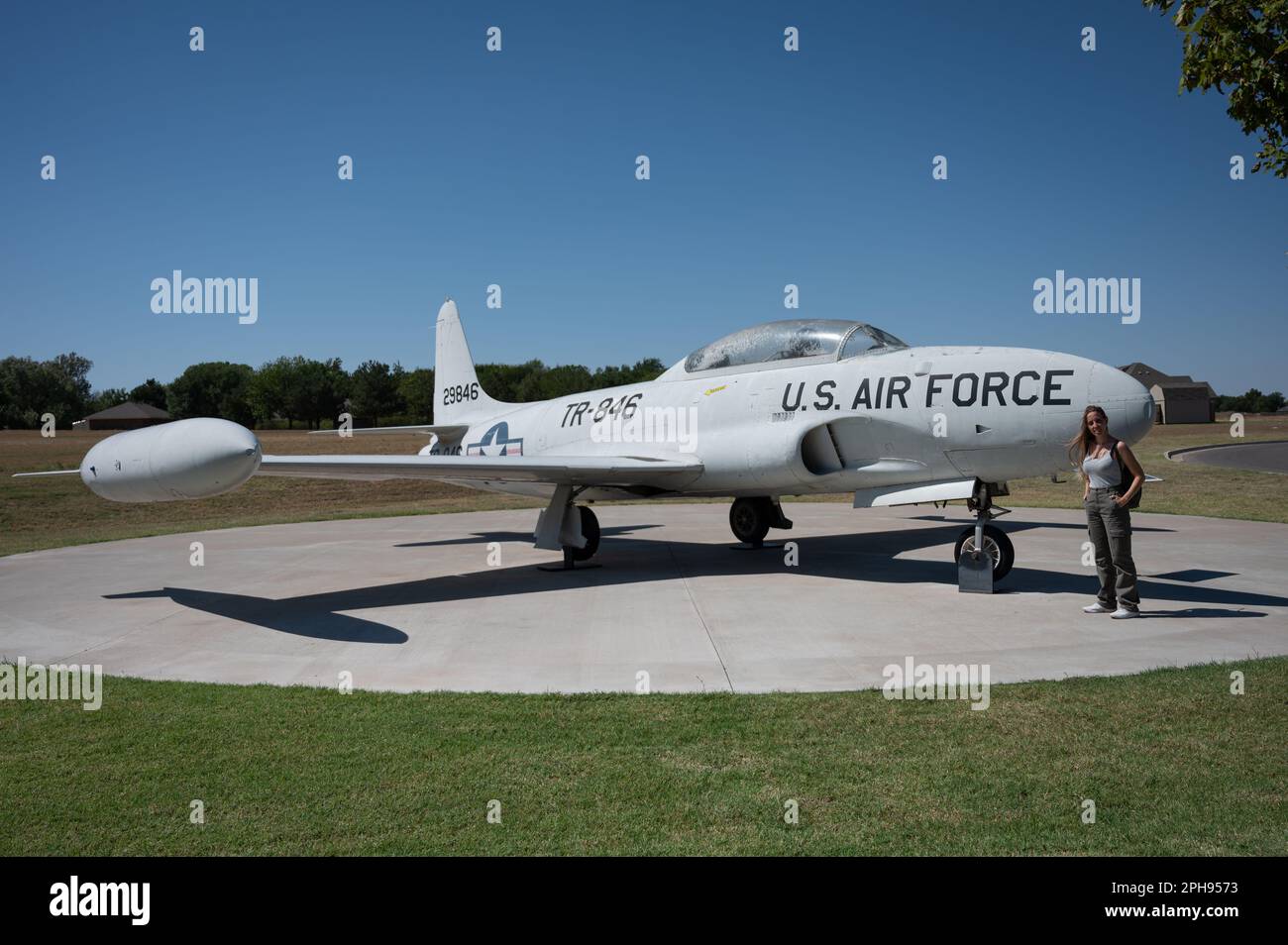 A smiling woman stands next to an old fighter jet Stock Photo - Alamy