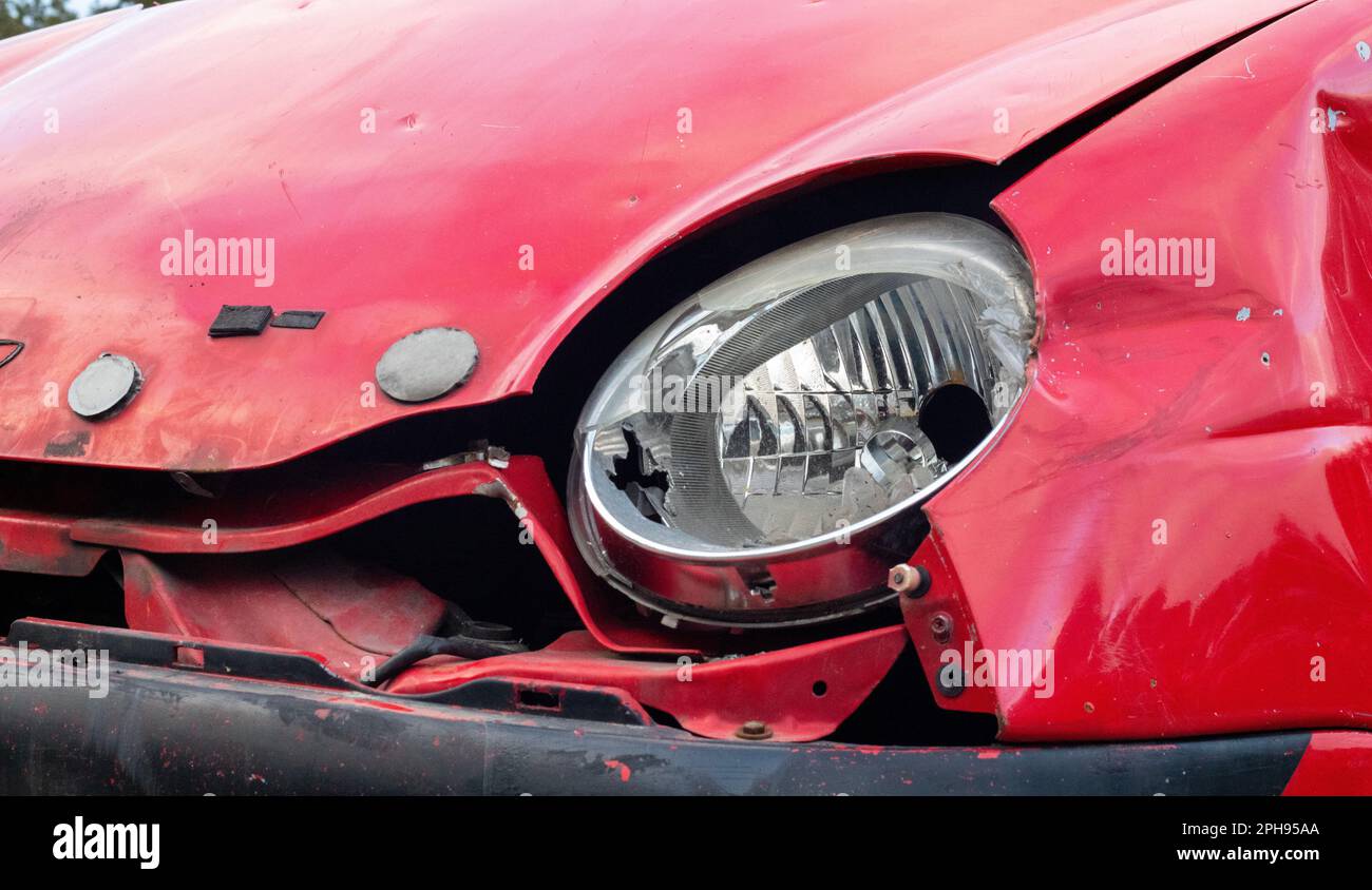 Broken headlight of a red car after a severe accident with a skewed ...