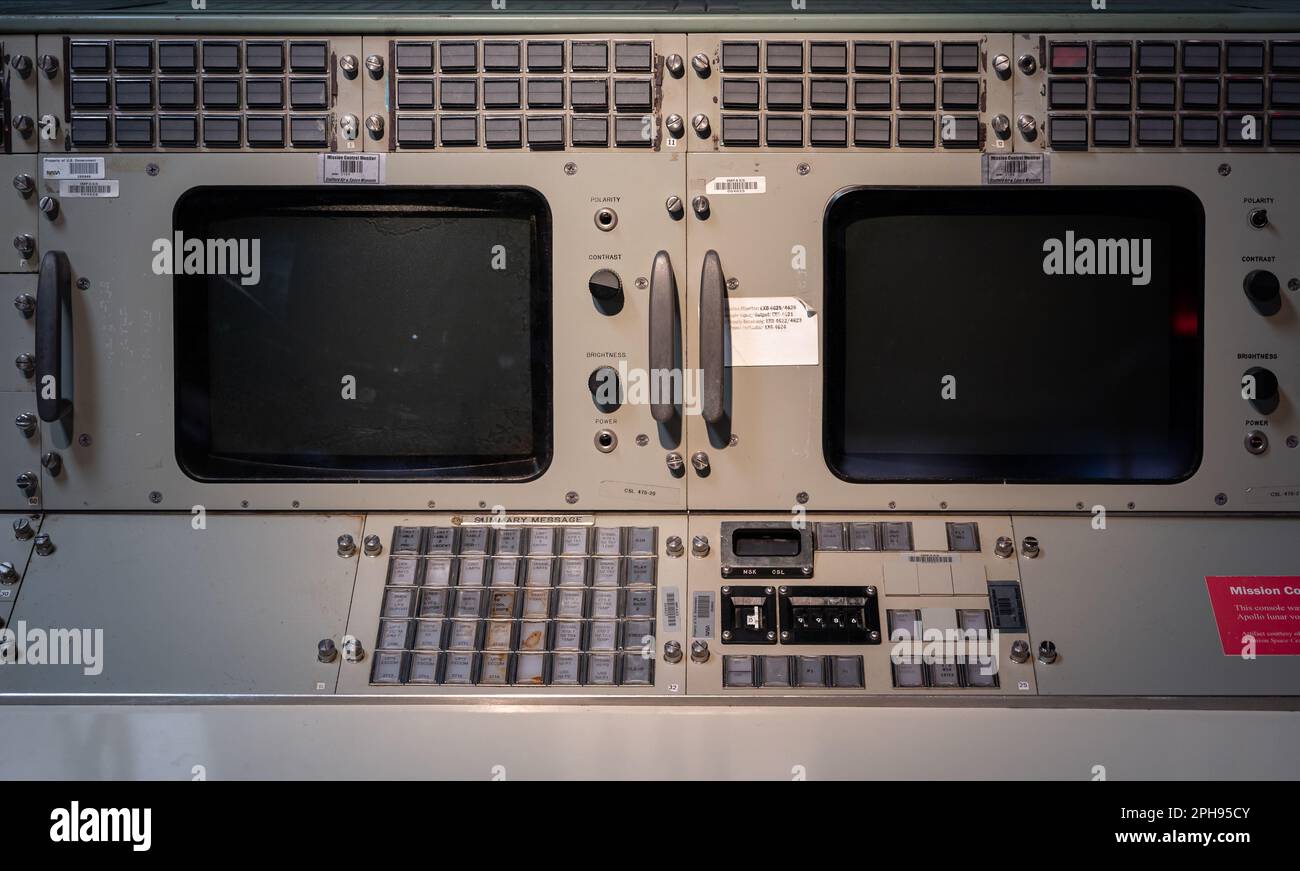 A high-resolution close-up of a classic mission control console, featuring various dials ...