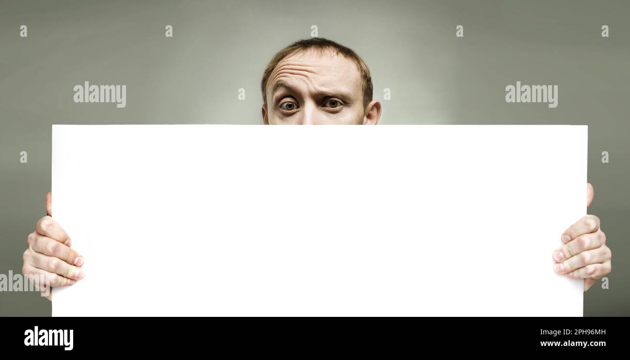 Man holding blank sign paper for advertising Stock Photo - Alamy
