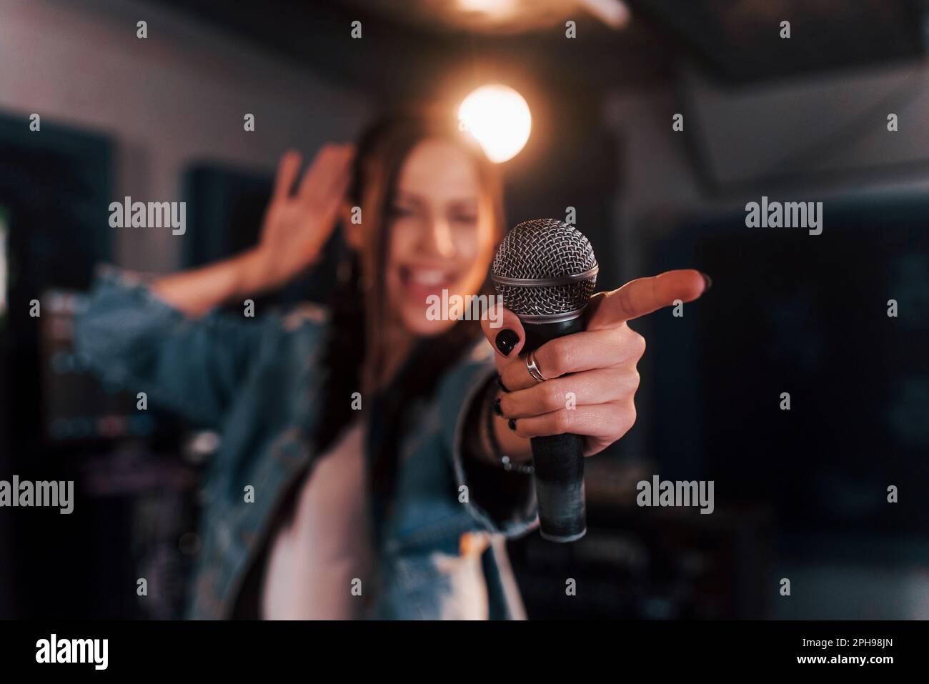 Close up view of microphone. Young beautiful female performer ...