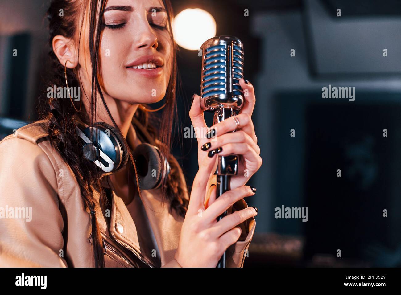 Young beautiful female singer rehearsing in a recording studio Stock ...