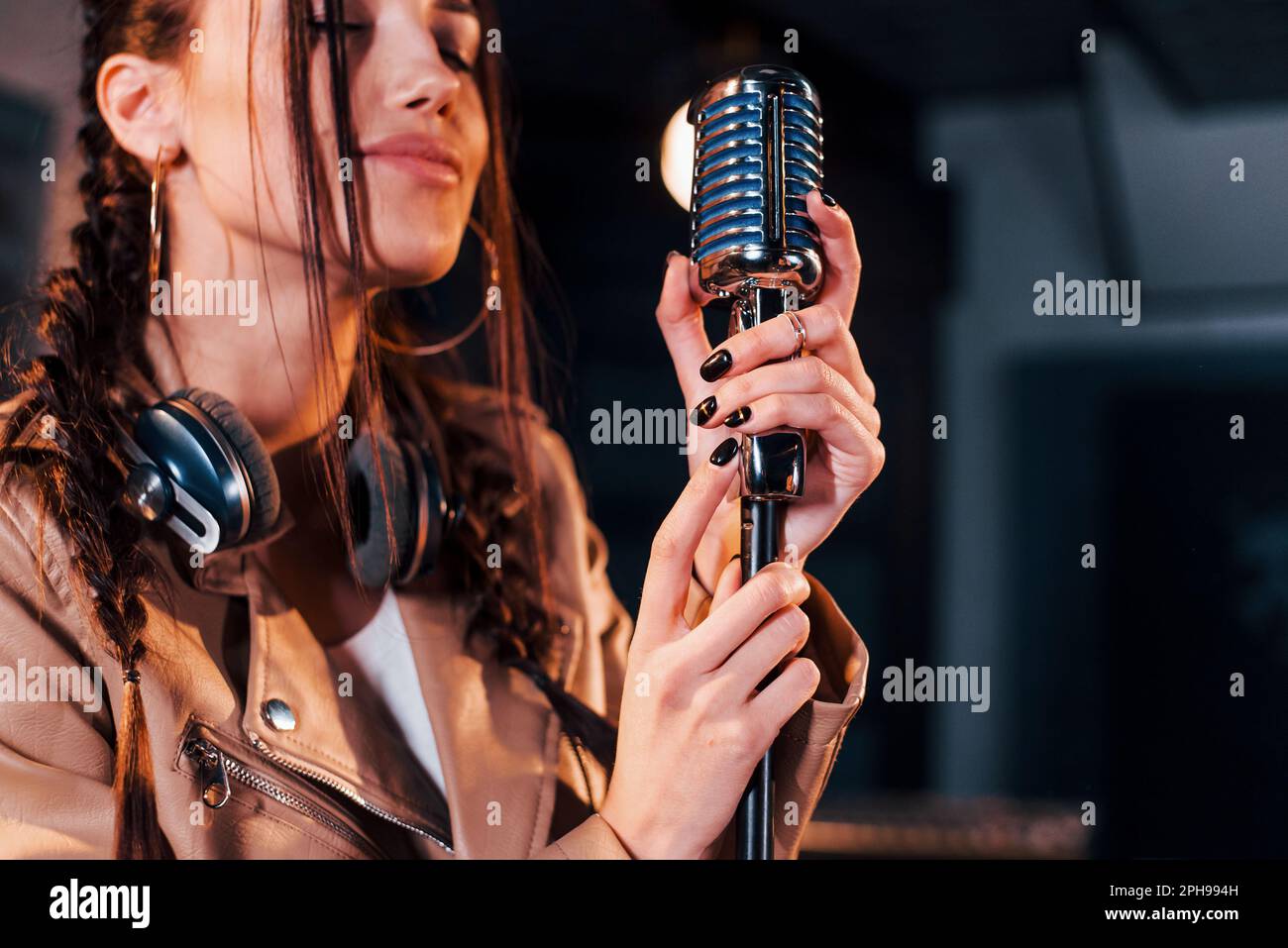 Young beautiful female singer rehearsing in a recording studio Stock ...