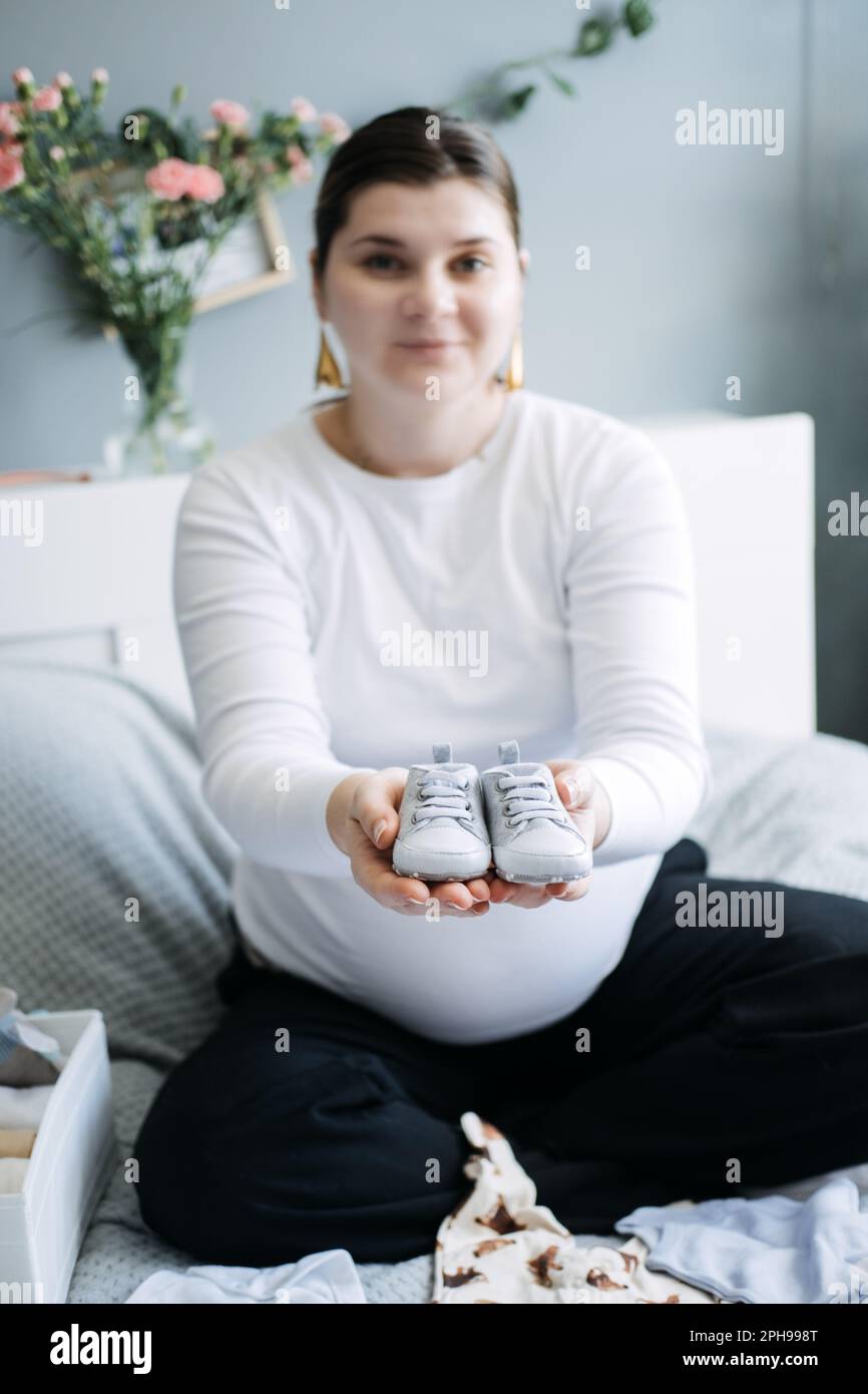 How to Organize Newborn Baby Clothes. Pregnant woman Using ornament ...