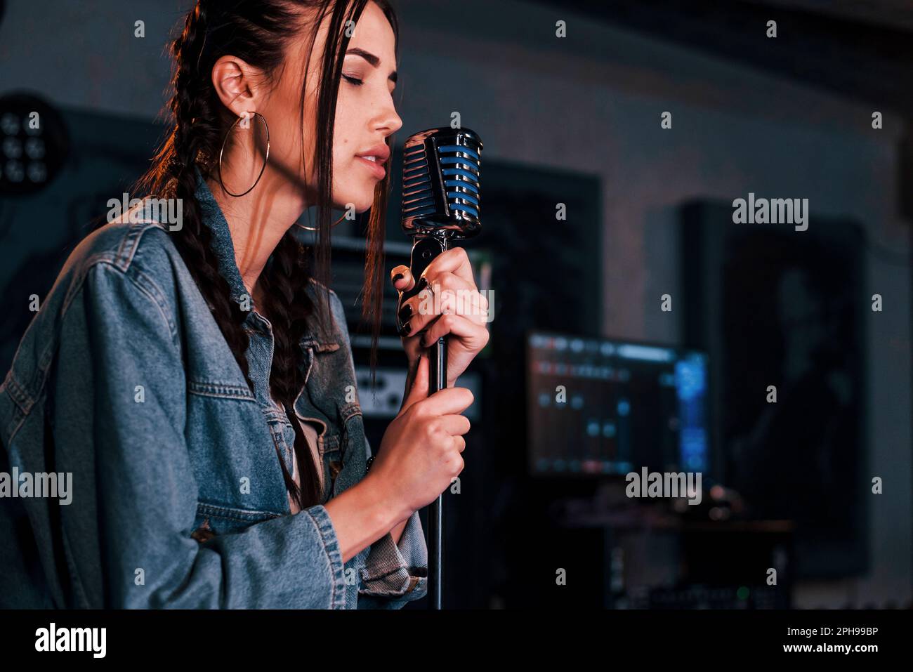 Young beautiful female singer rehearsing in a recording studio Stock ...
