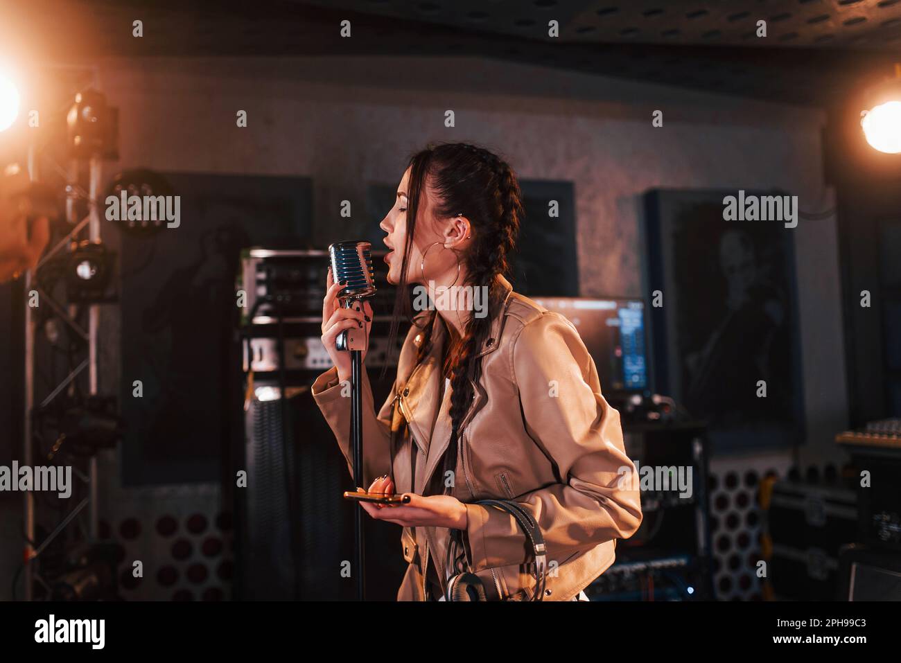 Young beautiful female singer rehearsing in a recording studio Stock ...