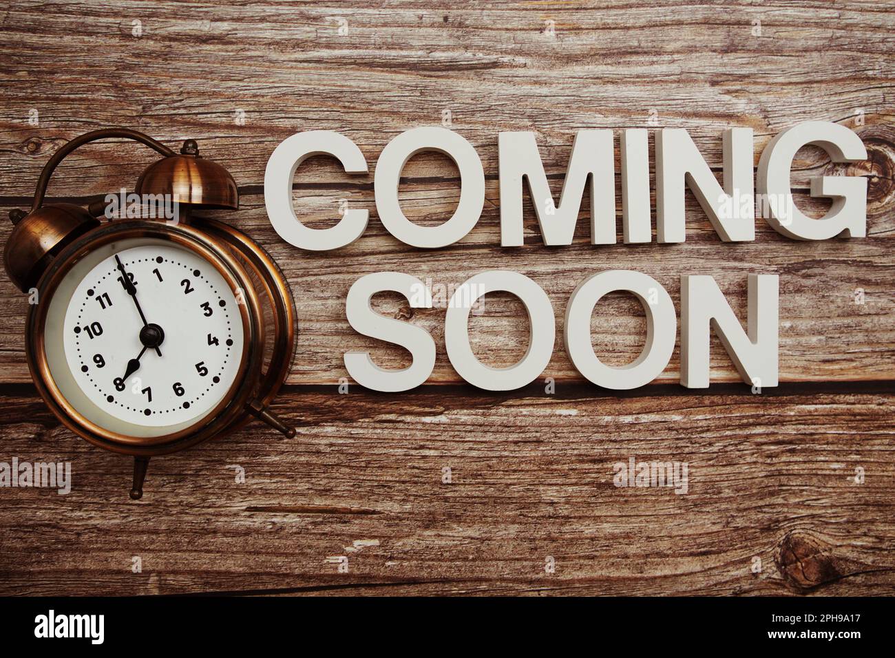 Coming Soon alphabet letter and alarm clock on wooden background Stock ...
