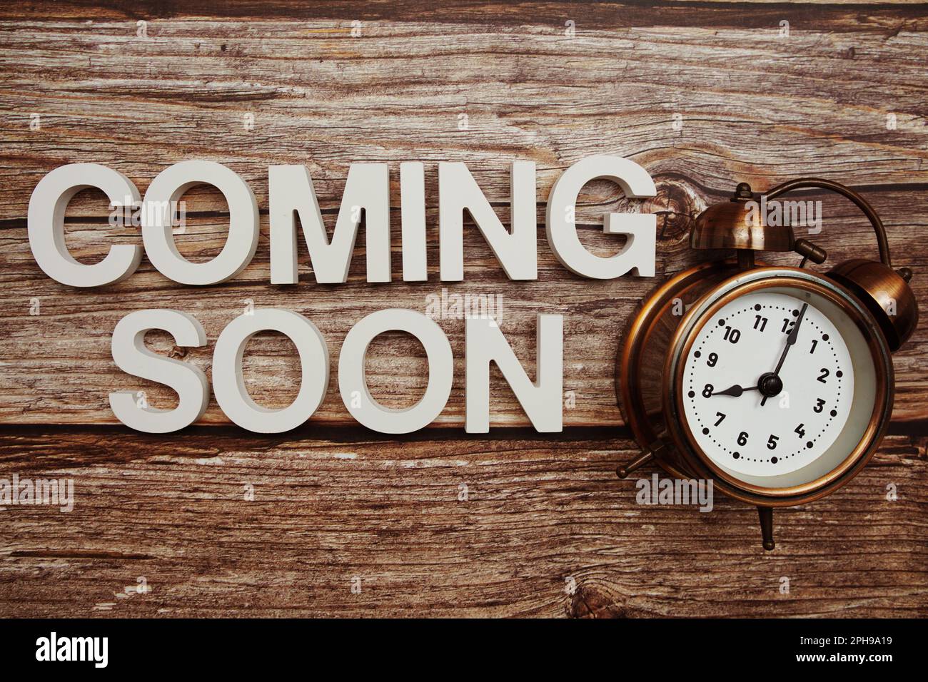 Coming Soon alphabet letter and alarm clock on wooden background Stock ...