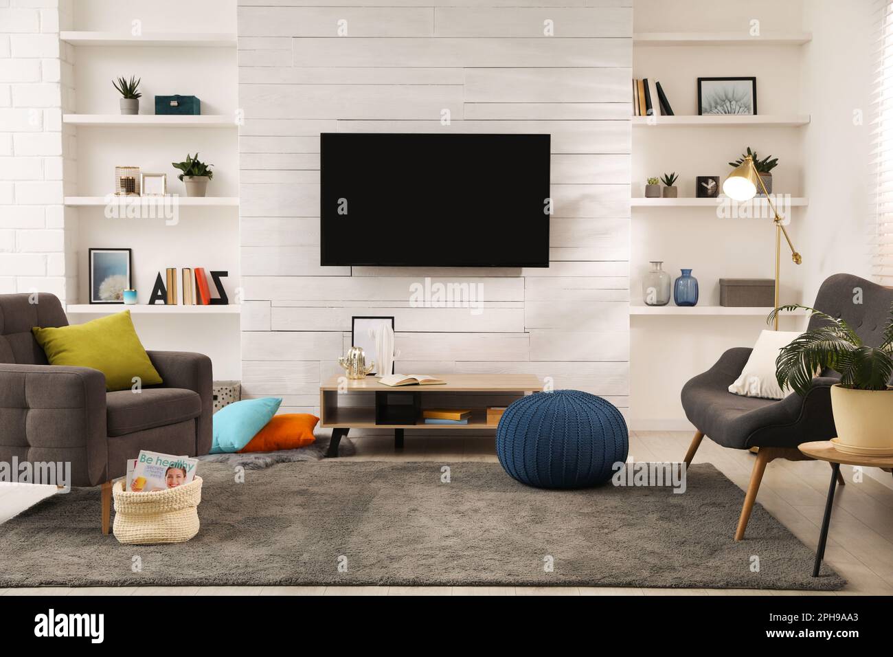 Cozy room interior with stylish furniture, decor and modern TV set ...