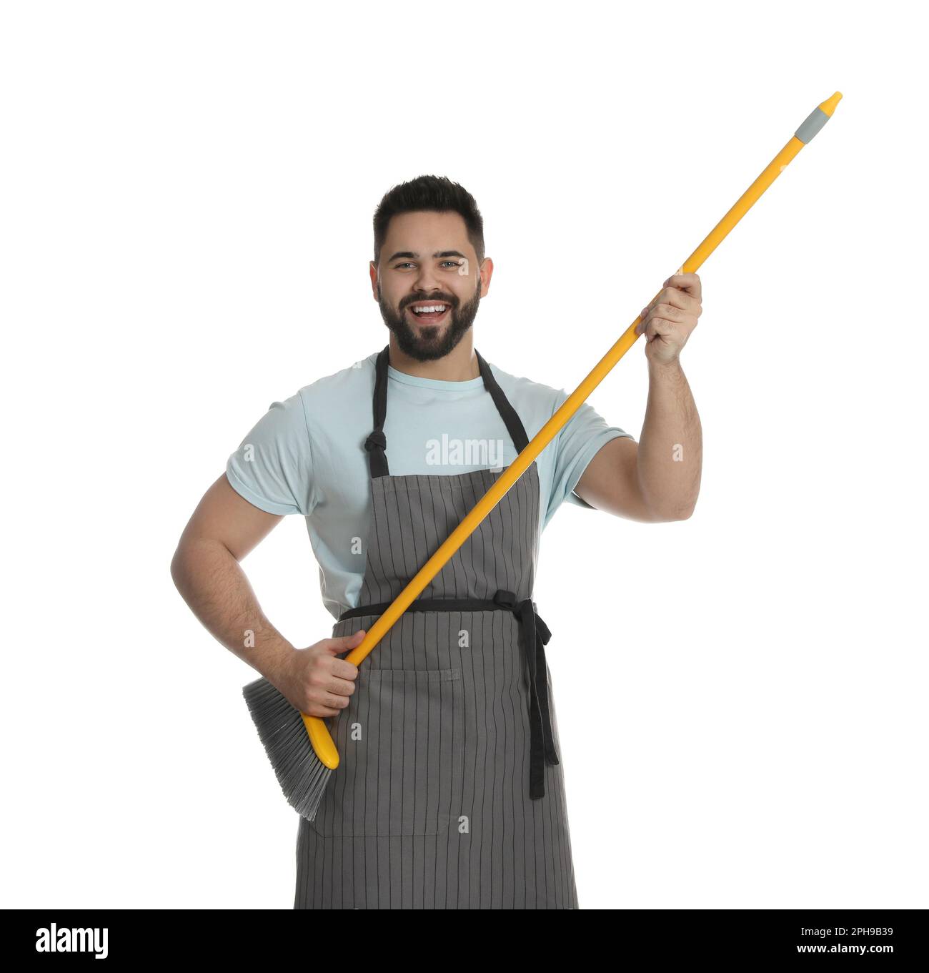 Young man with yellow broom on white background Stock Photo - Alamy