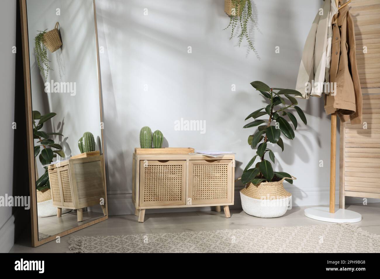 Stylish hallway room interior with wooden commode, coat rack and large ...