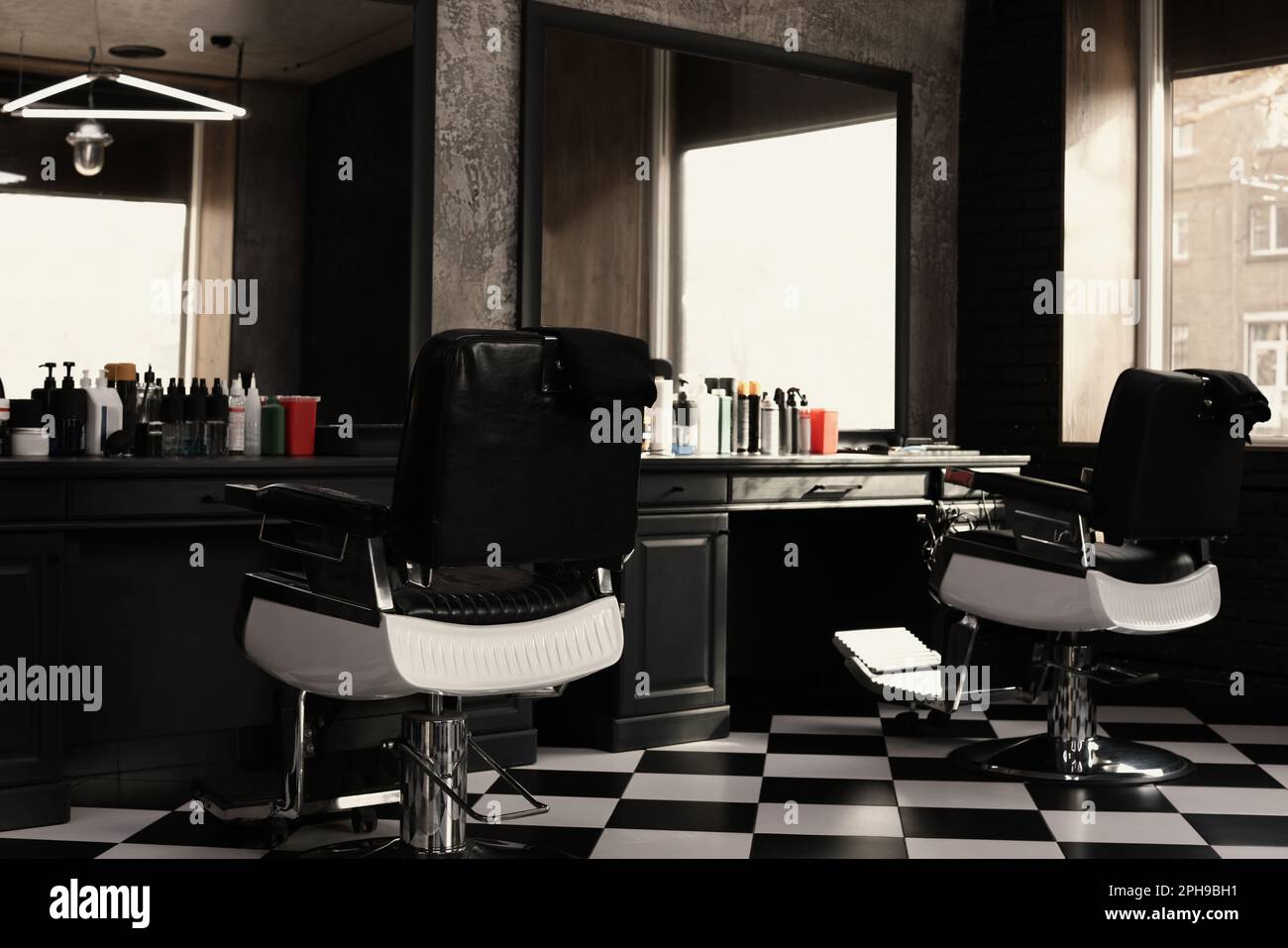 Stylish monochrome interior of modern barbershop. Equipped workplace ...