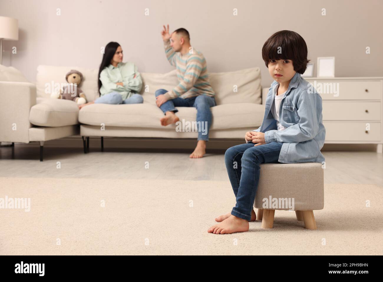 Couple arguing at home, focus on their upset child Stock Photo - Alamy
