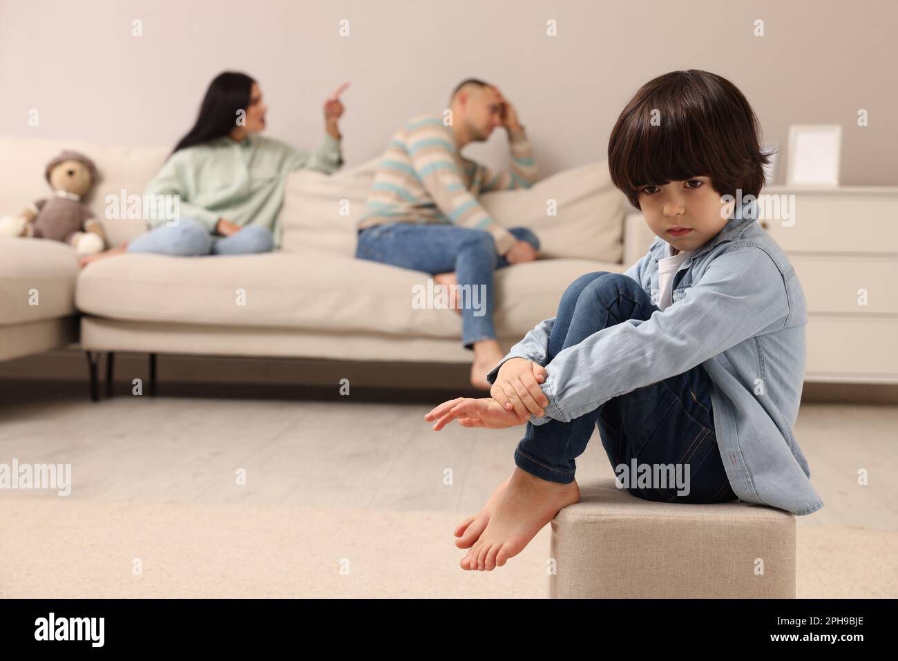 Couple arguing at home, focus on their upset child Stock Photo - Alamy