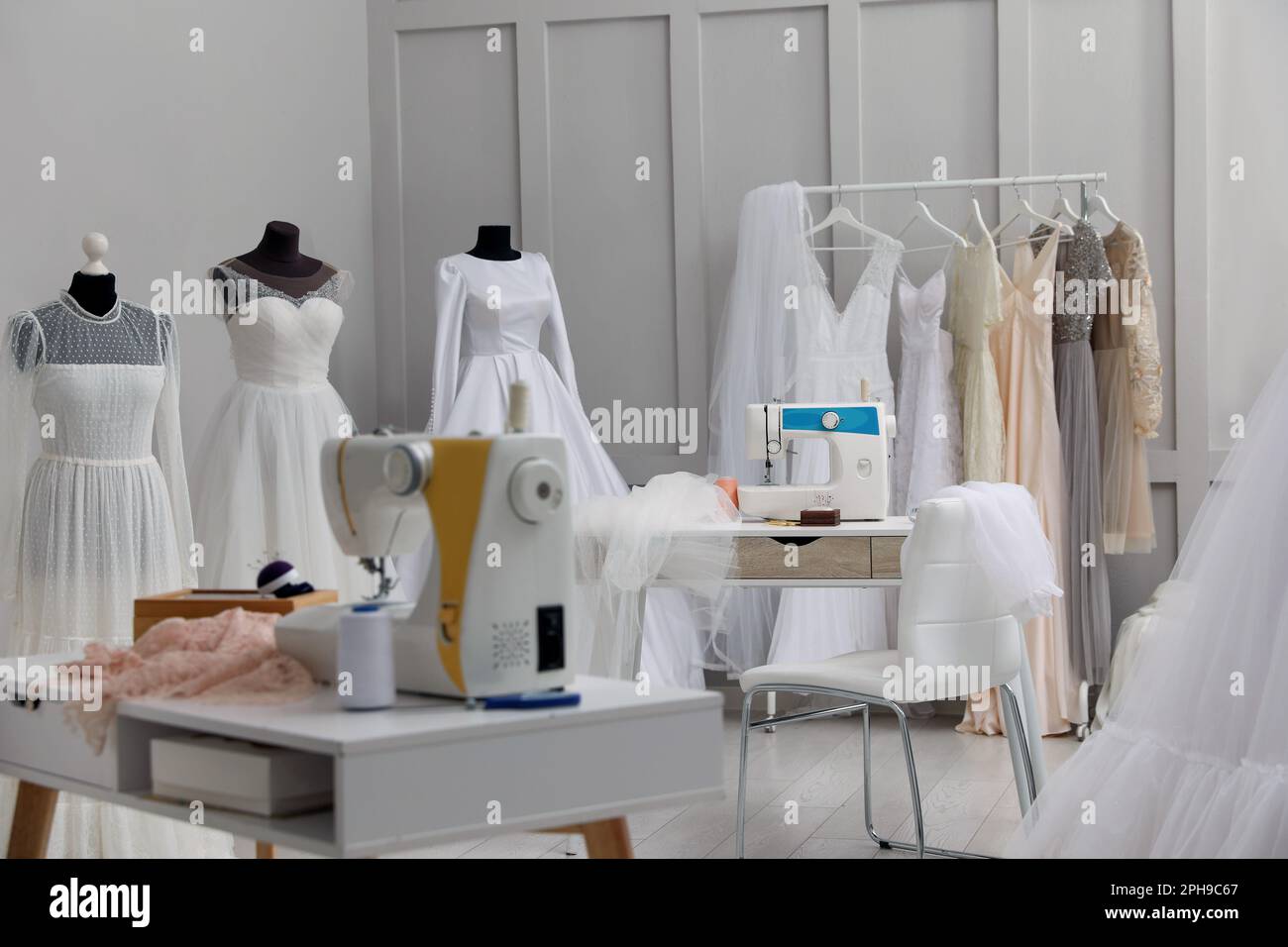 Dressmaking workshop interior with wedding dresses and equipment Stock ...