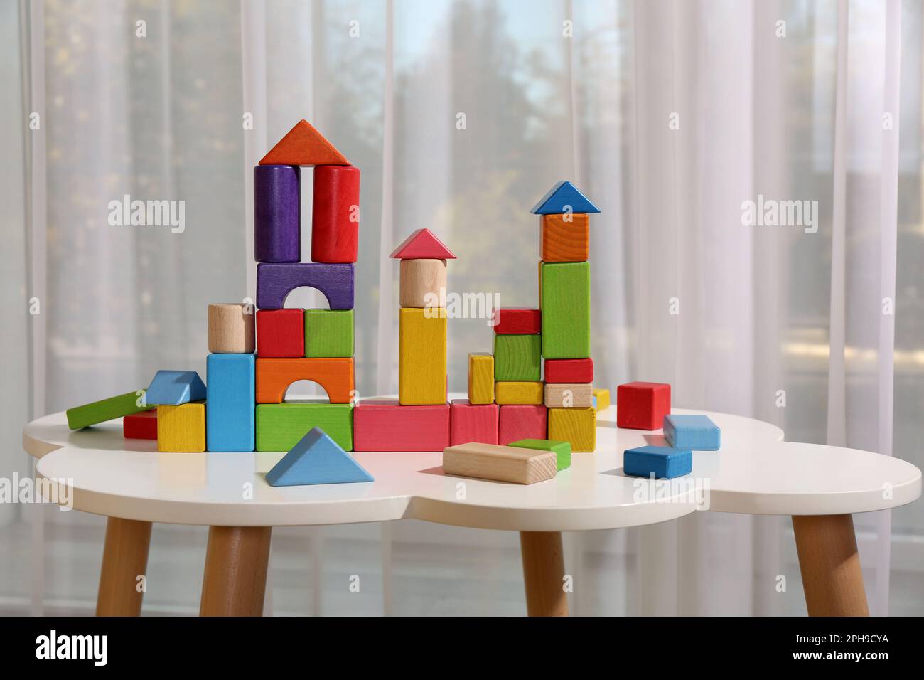 Colorful building blocks on white table in playroom Stock Photo - Alamy