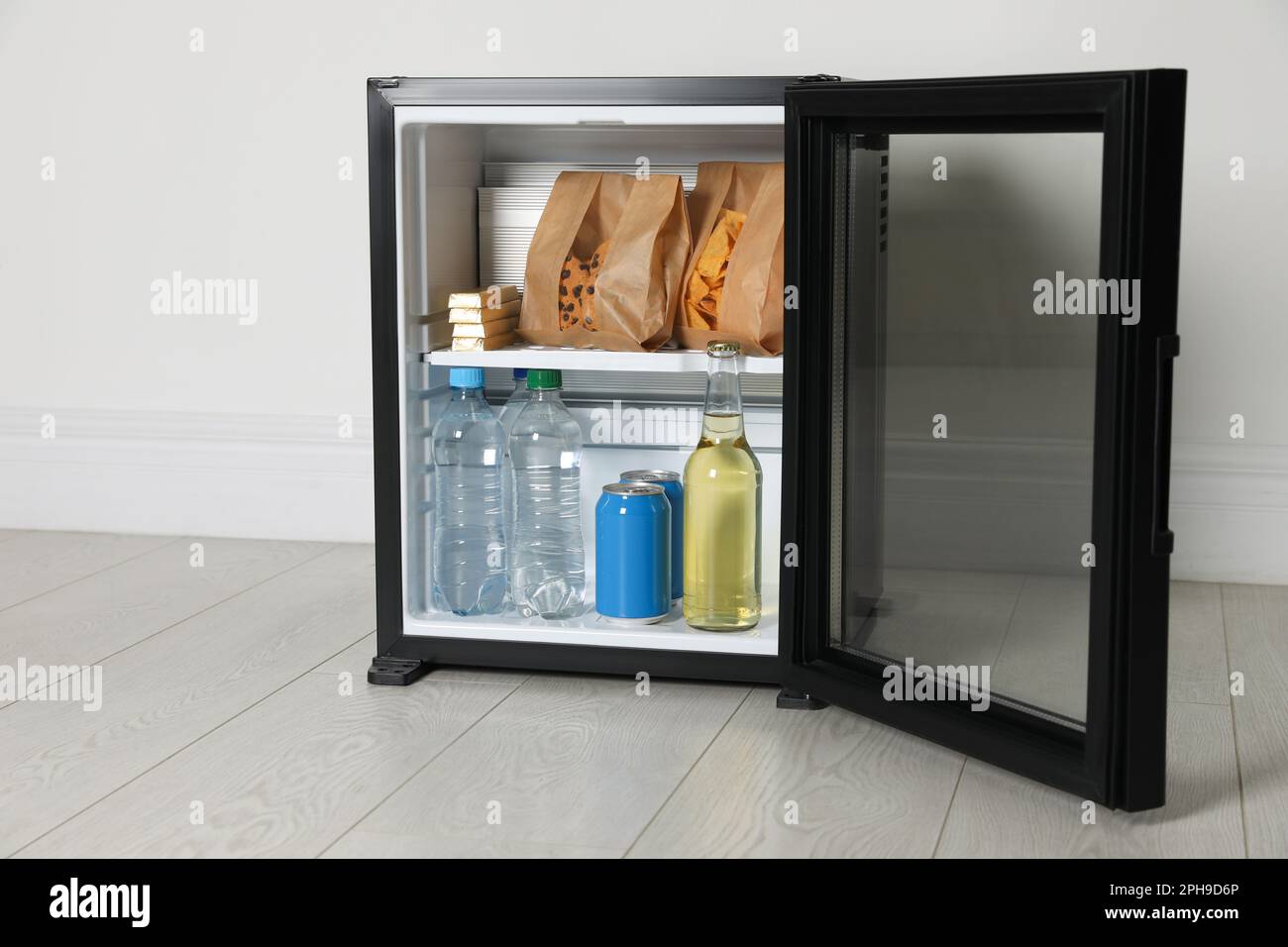 Mini bar filled with food and drinks near white wall indoors Stock ...