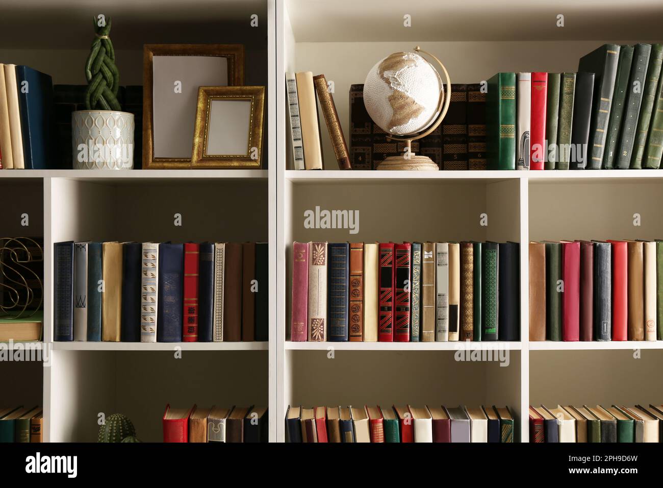 Collection of books and decor elements on shelves. Home library Stock ...