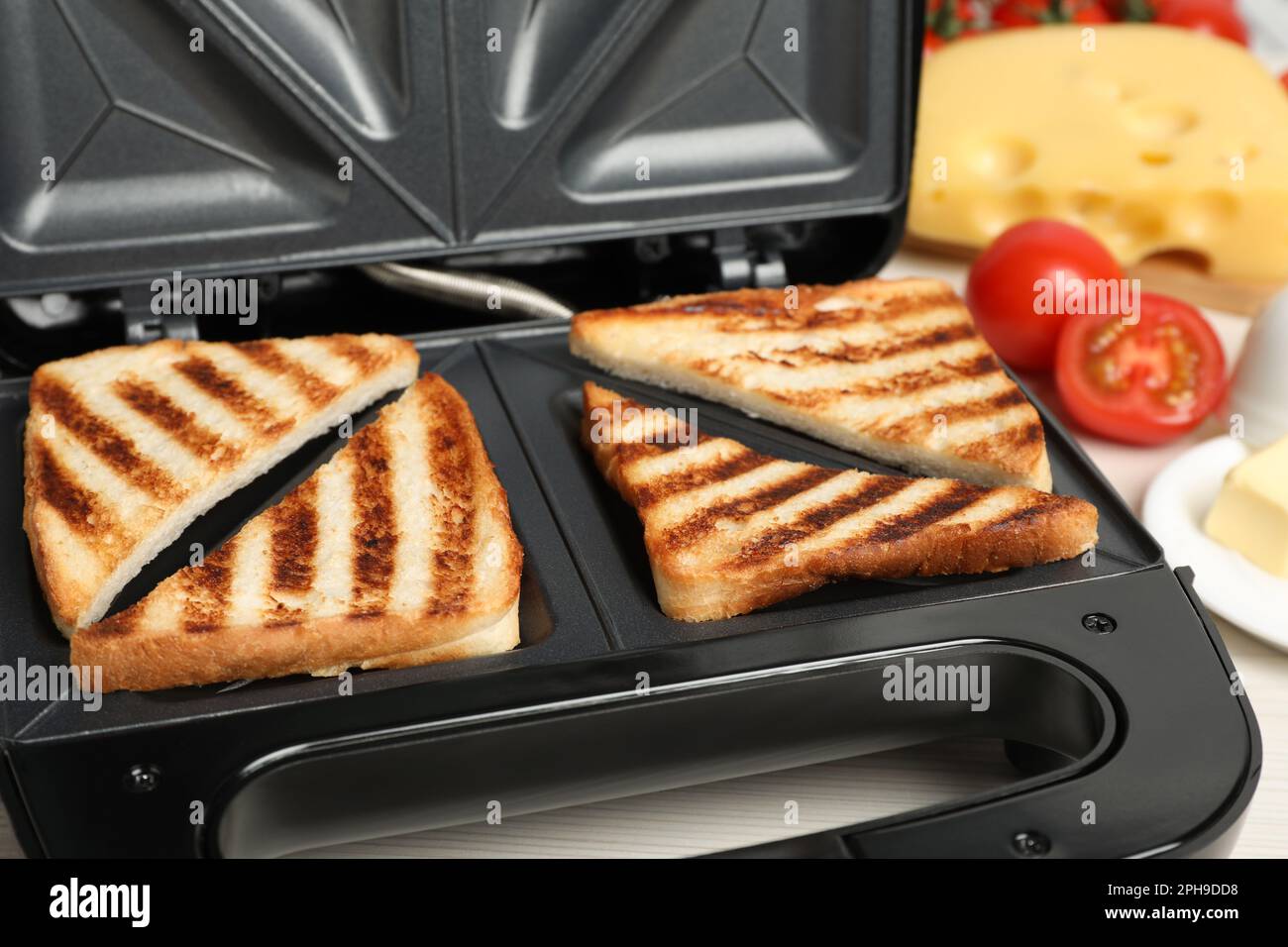 Modern sandwich maker with bread slices, closeup Stock Photo - Alamy