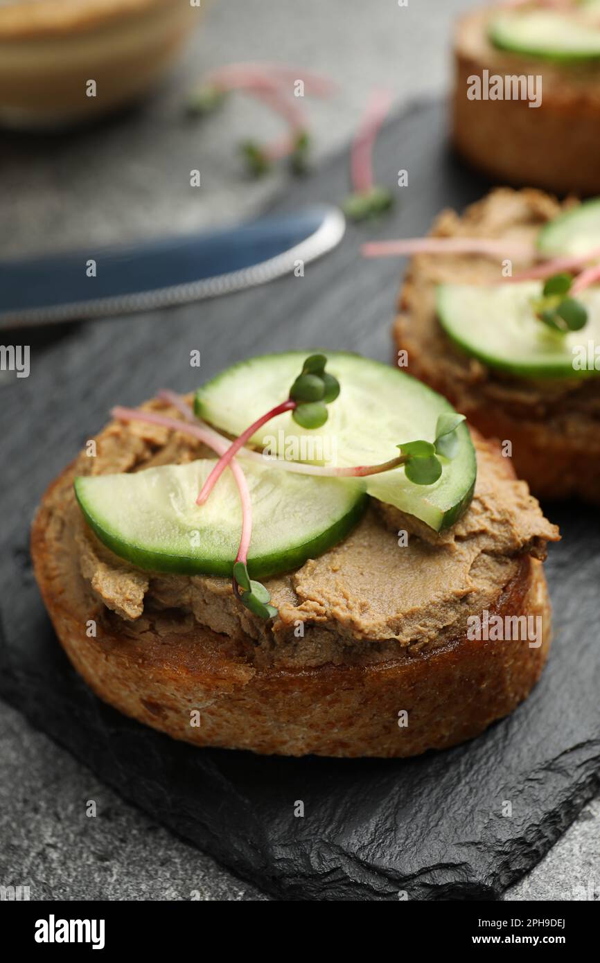 Slices of bread with delicious pate, cucumber and microgreens on grey ...