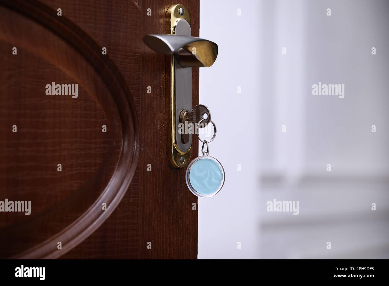 Closeup view of door with key in room, space for text Stock Photo - Alamy