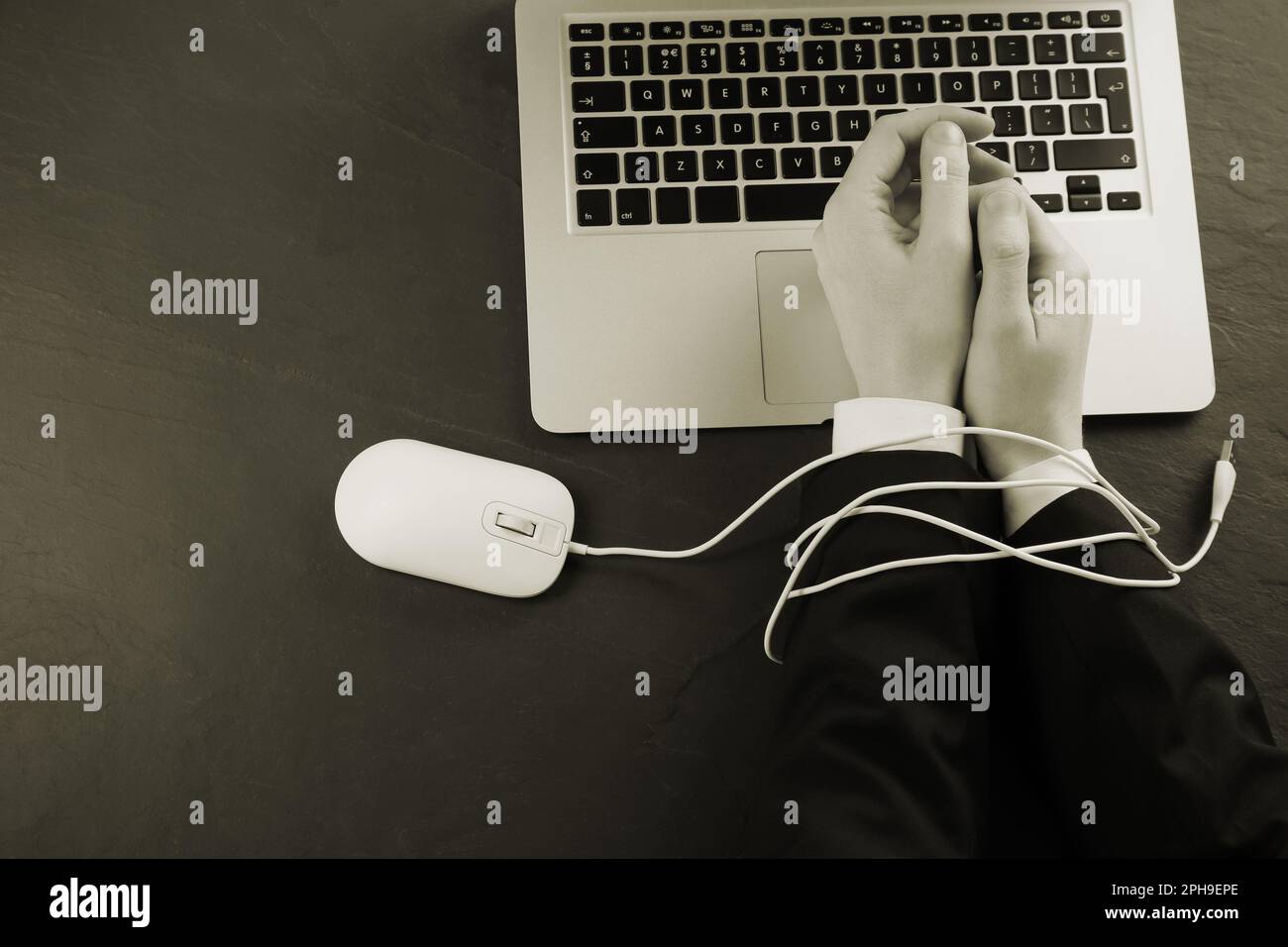 Top view of woman with her hands tangled in cable of computer mouse at ...