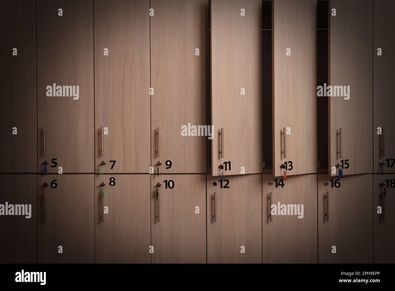 Many wooden lockers with keys and numbers on doors. Vignette effect ...