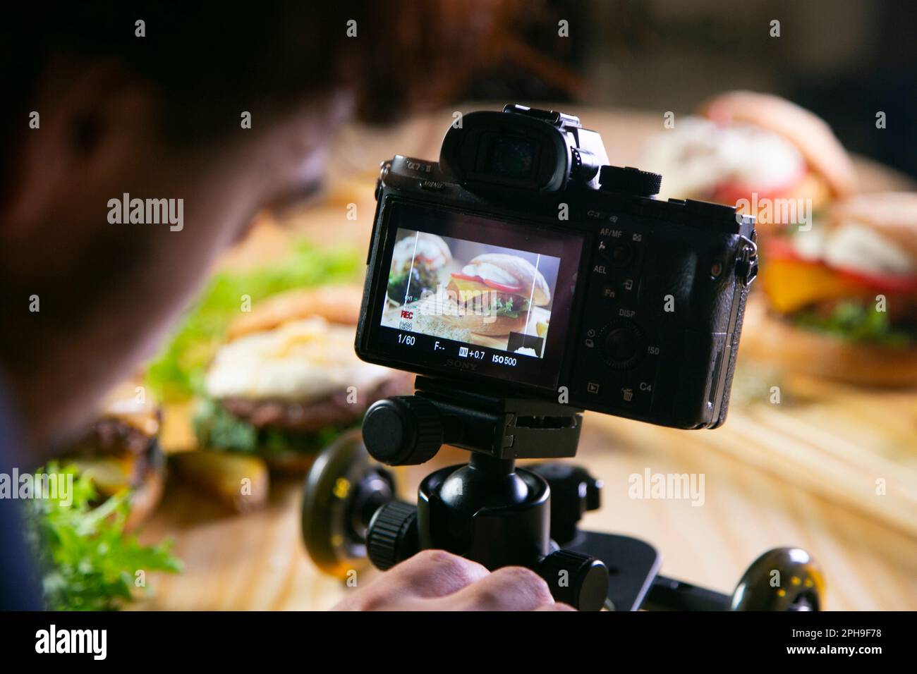 A person is using a camera to take a picture of food and beverage on a ...
