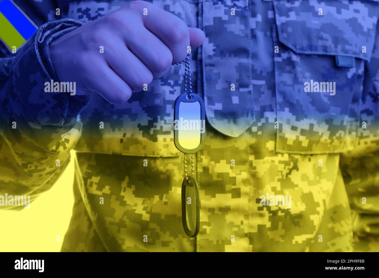 Closeup view of defender in camouflage uniform holding military ID tags ...