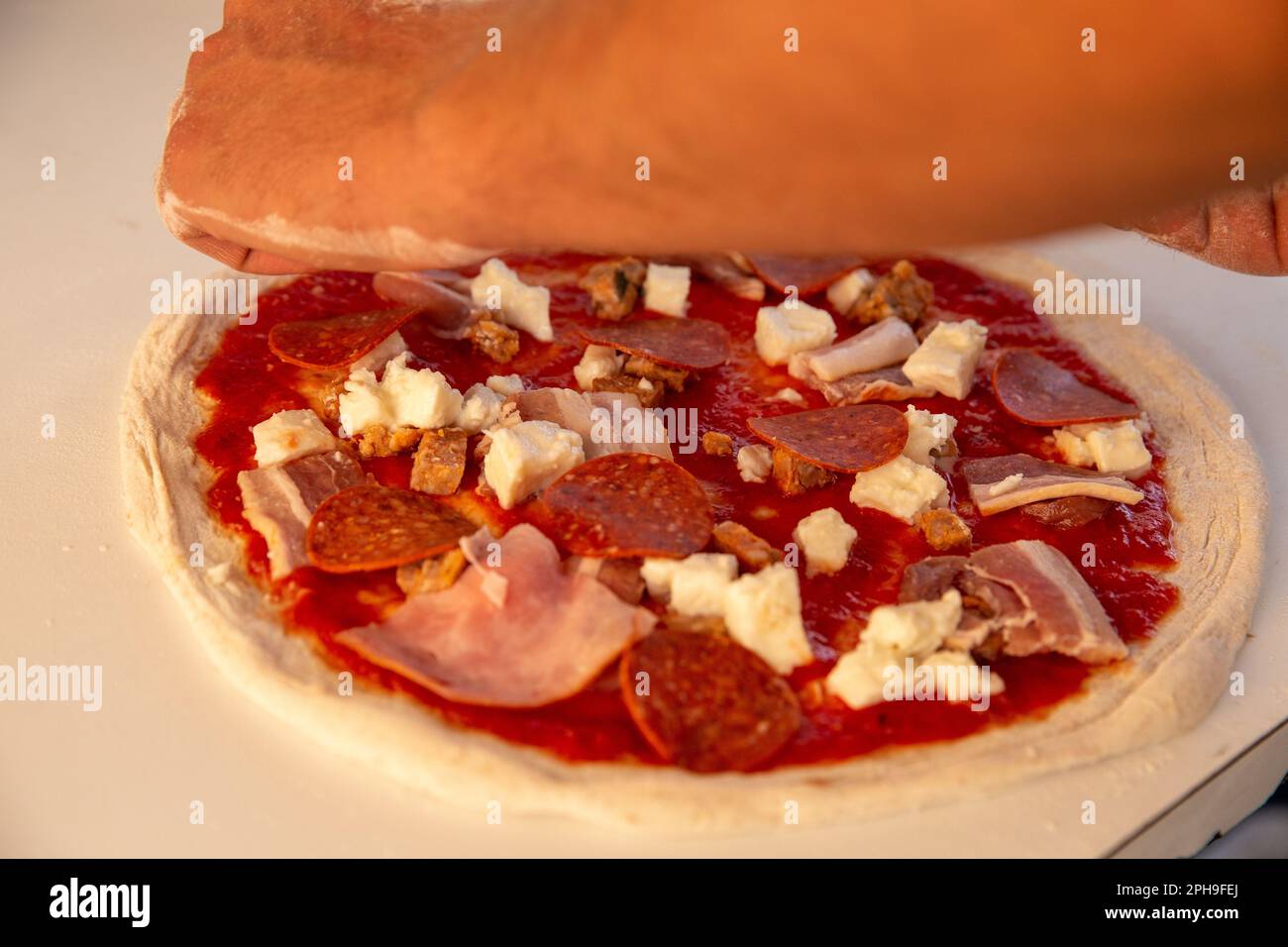 bacon and Pepperoni pizza being topped Stock Photo - Alamy