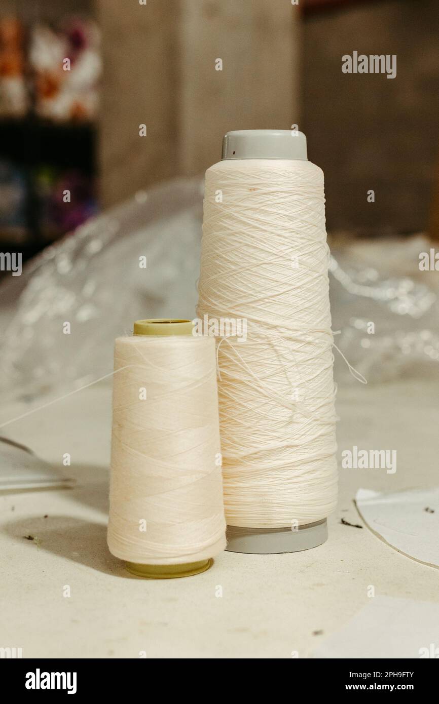 This image shows a collection of white thread spools sitting on top of ...