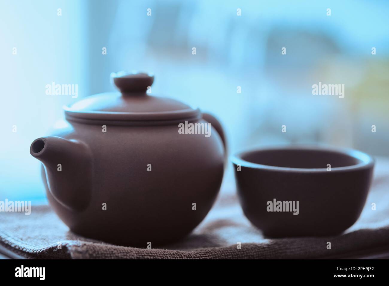 Teapot and tea cup made of yixing clay stands on a tea tray. Chinese ...