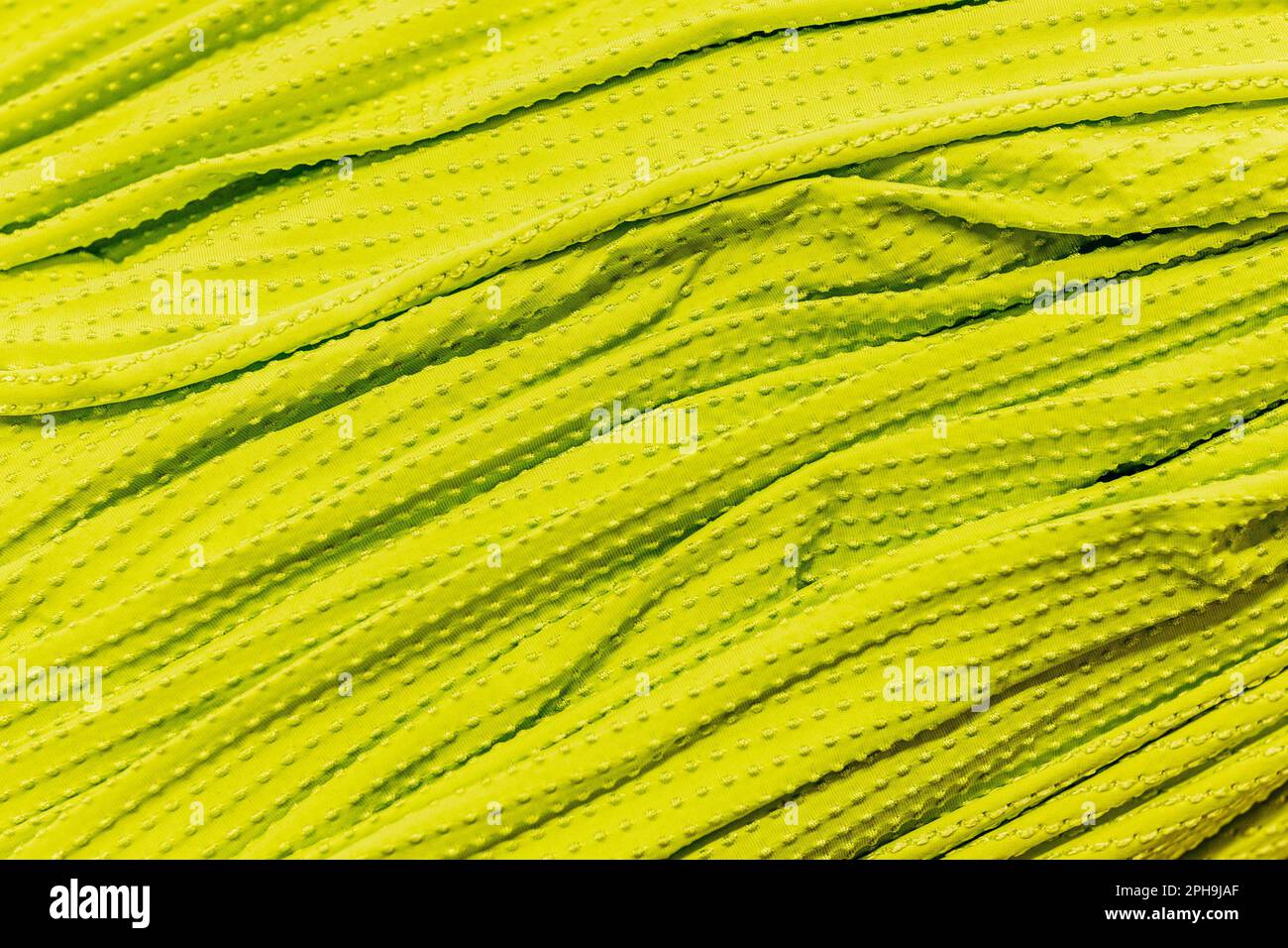Vibrant yellow cloth, ideal for use as a backdrop in photography, video ...