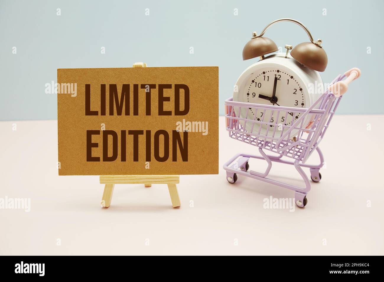 Limited Edition text message with alarm clock on blue and pink background Stock Photo - Alamy