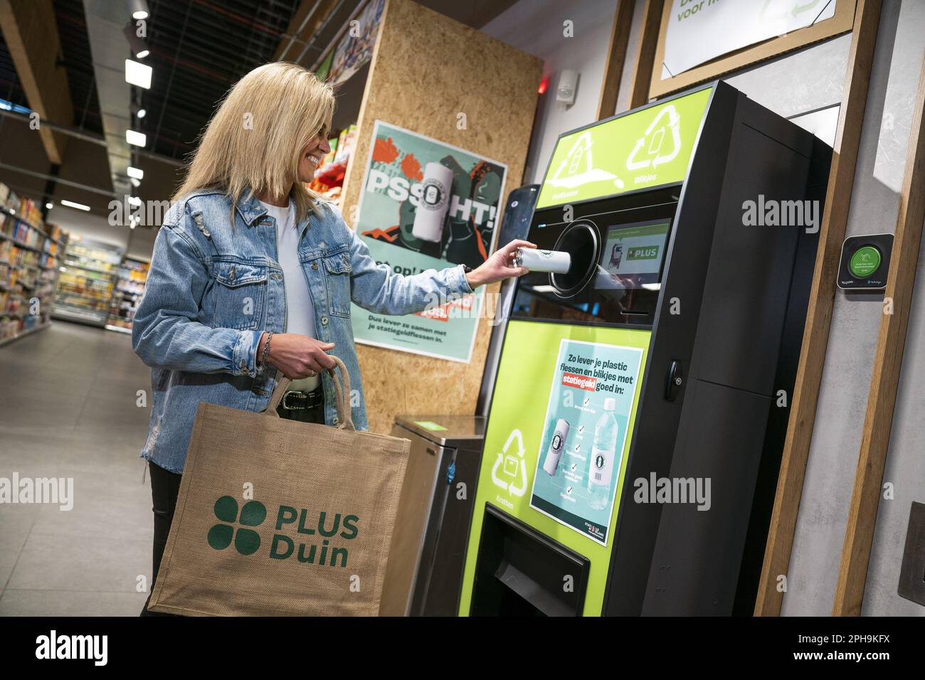 ALMERE - A consumer symbolically hands over a can at a collection point ...