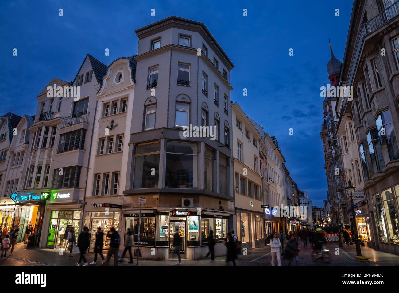 Picture of facades of a medieval street at dusk, with shops and ...