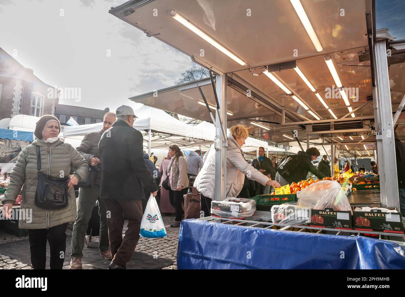 Picture of stalls of Vaals Farmers market iwith crowd of people passing ...