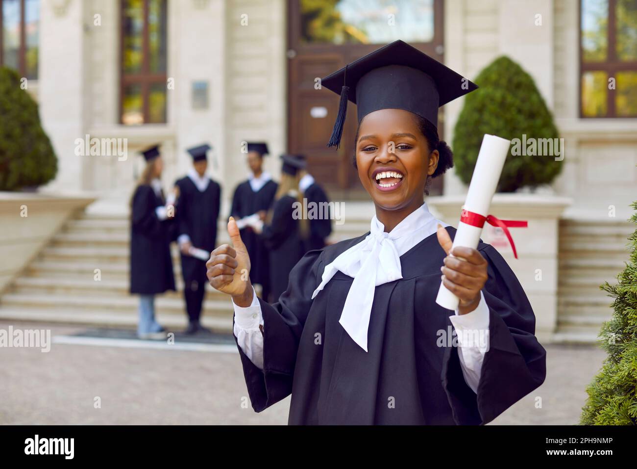 Happy successful African student girl in graduation cap and gown ...