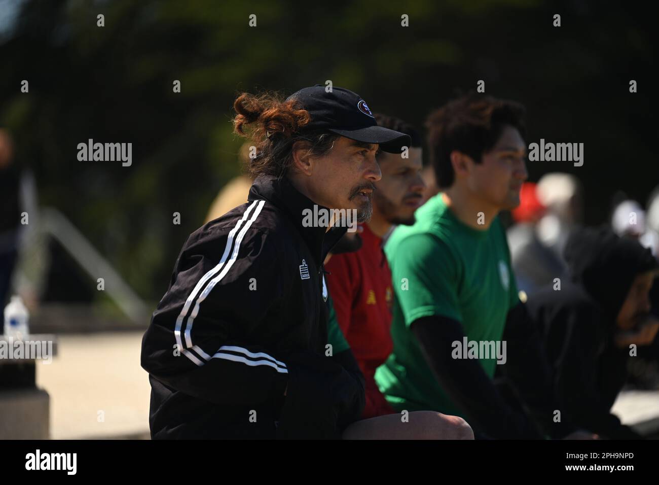 A group of people enjoying the view of a soccer game in the field ...