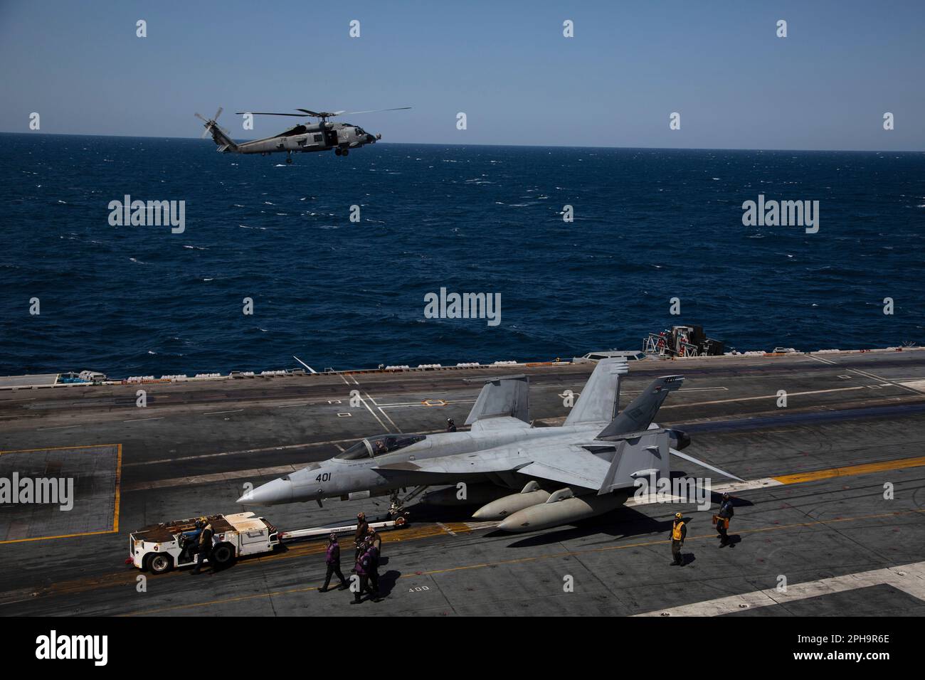 U.S. Navy MH-60S Hawk helicopter, top, and F-18 Super Hornets are seen ...
