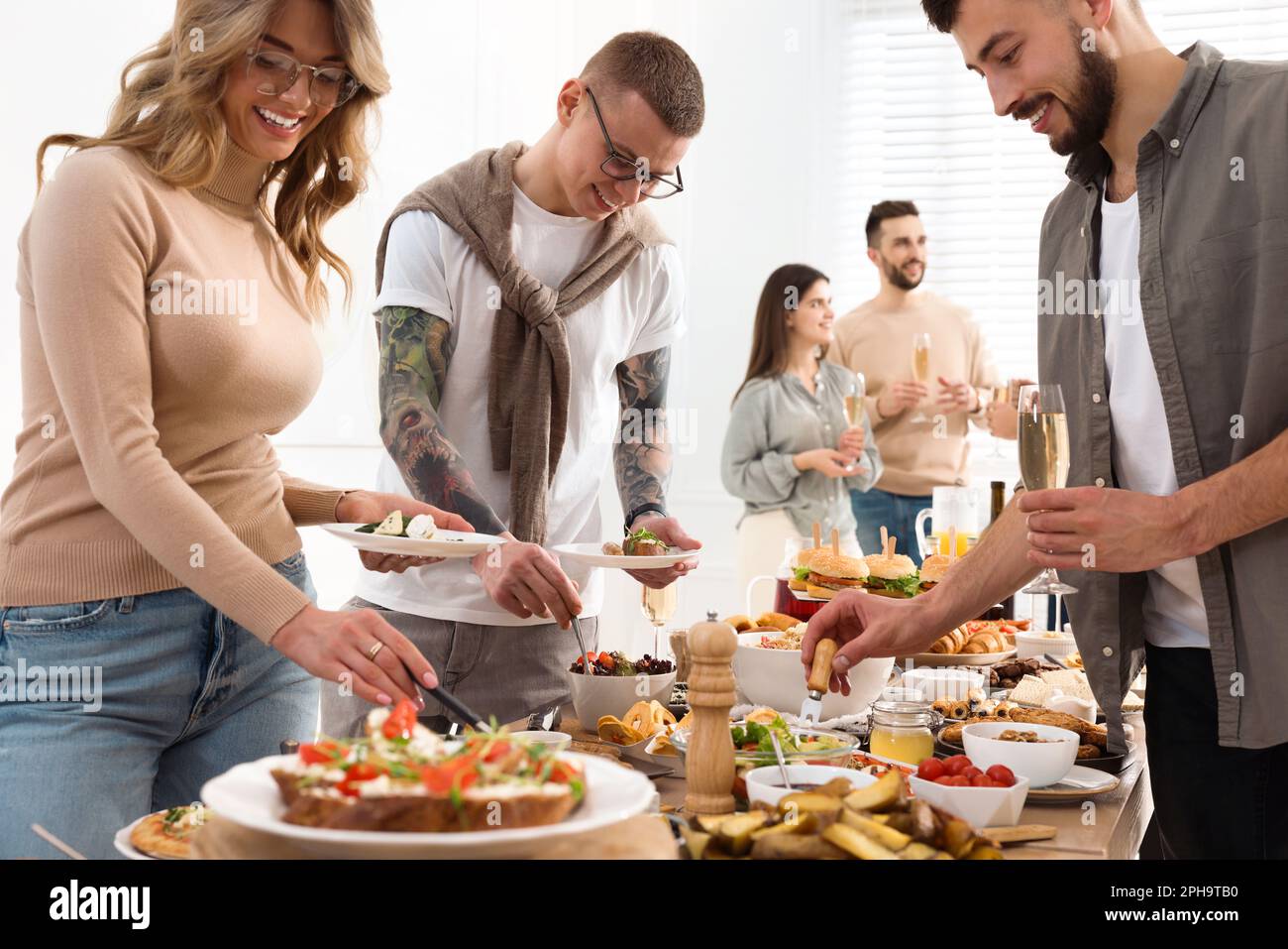Group of people enjoying brunch buffet together indoors Stock Photo - Alamy