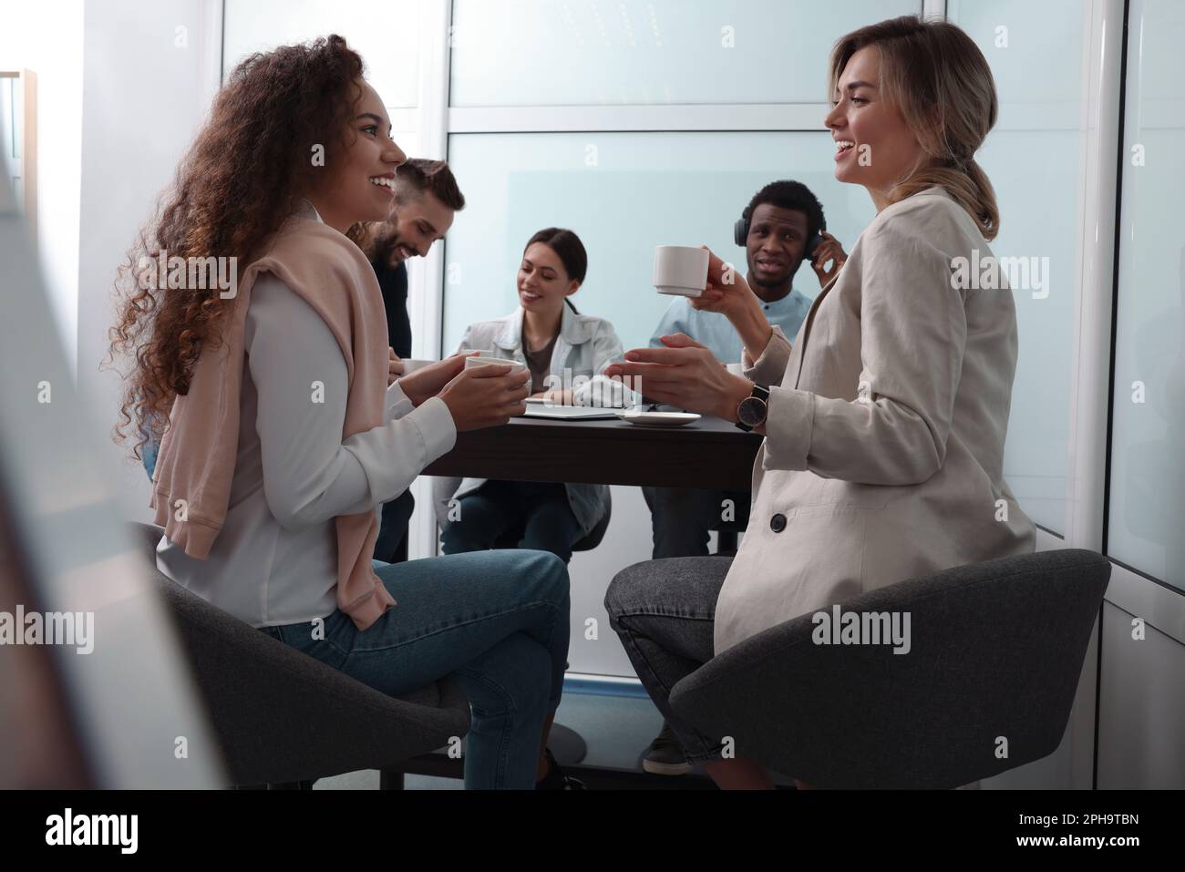 Team of employees enjoying coffee break together in office. Startup ...