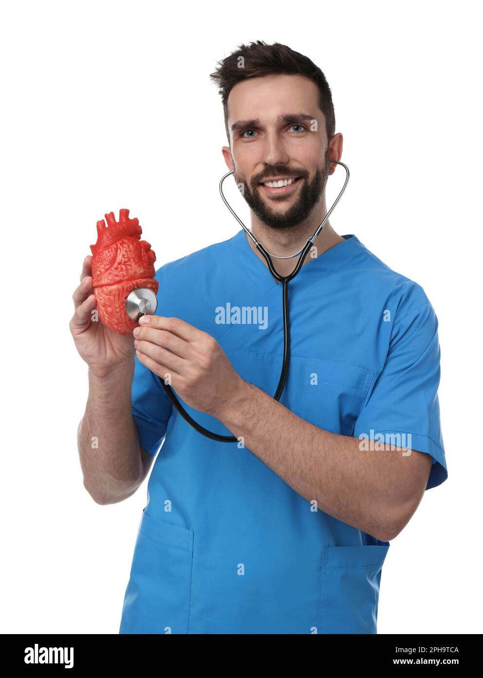 Doctor with stethoscope and model of heart on white background ...