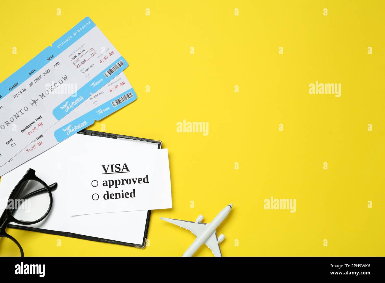 Flat lay composition with passport, toy plane and tickets on yellow ...