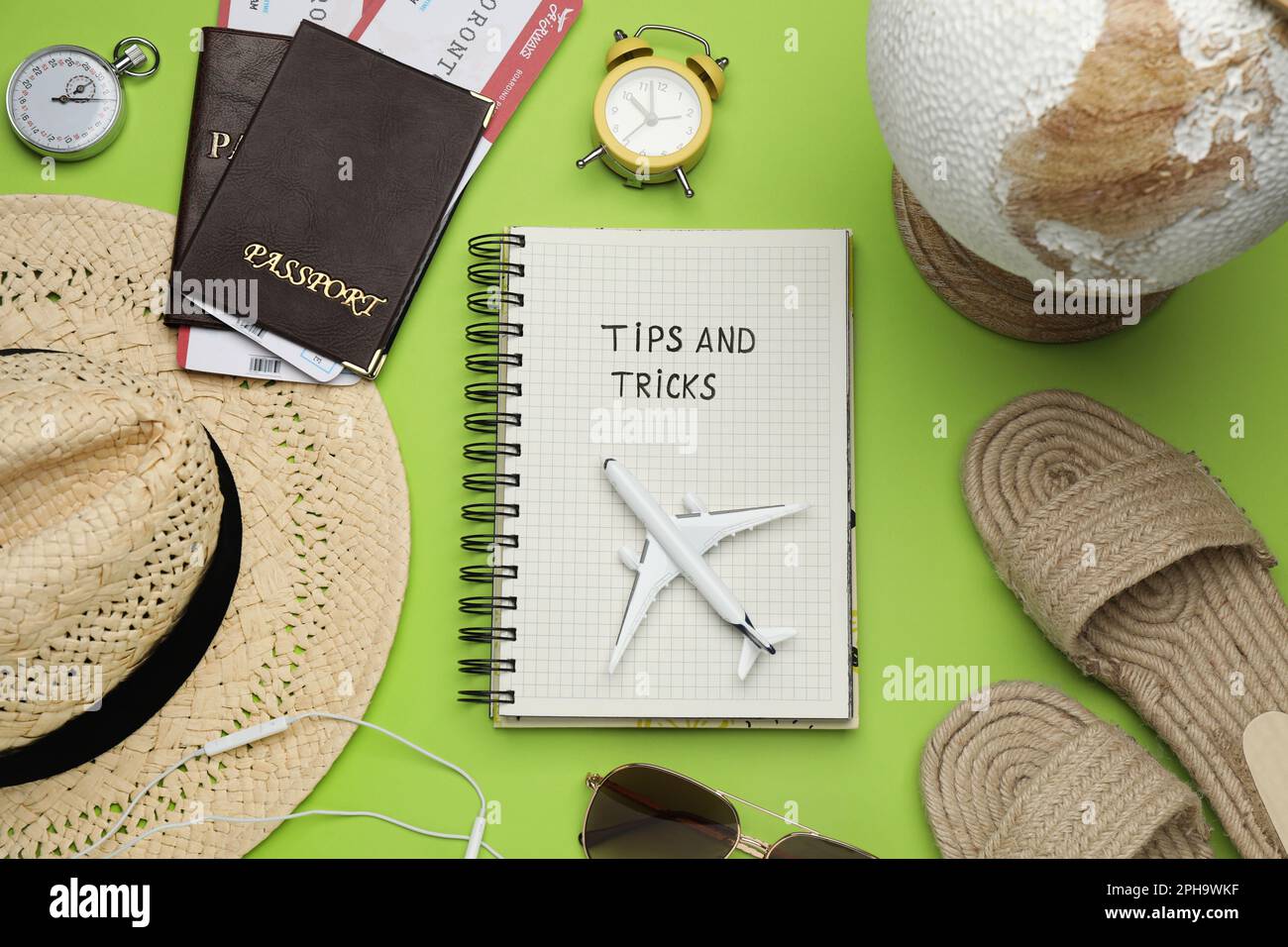 Flat lay composition with notebook on green background. Tips and Tricks ...